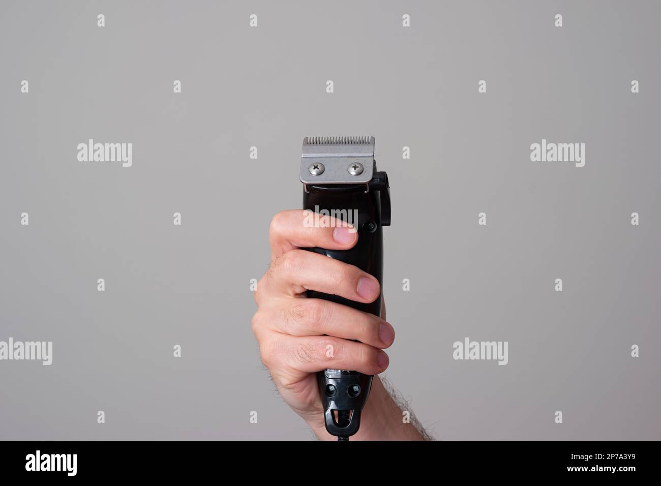 Electric hair trimmer held in hand by Caucasian male hand close up shot ...