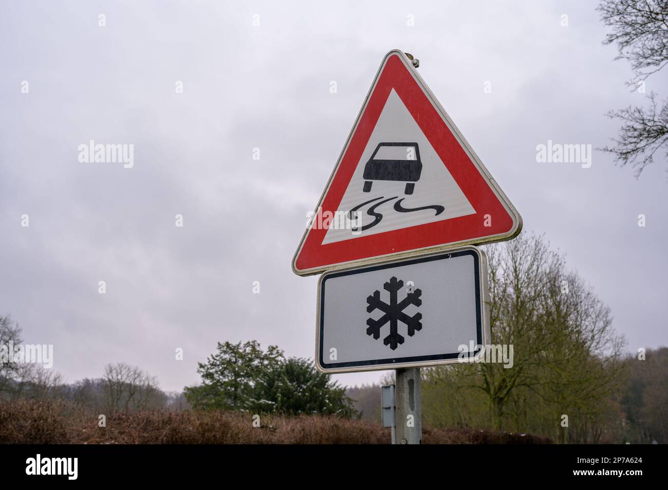 Slippery road and ice or snow warning sign against gray sky Stock Photo ...