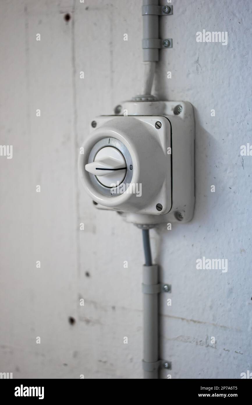 Wall mounted old fashion industrial grade power switch close up shot no ...