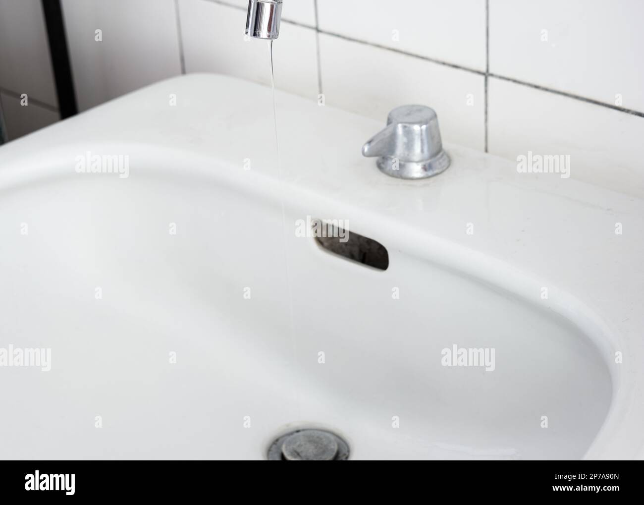 Bathroom sink and faucet with flowing stream of water. Close up shot ...