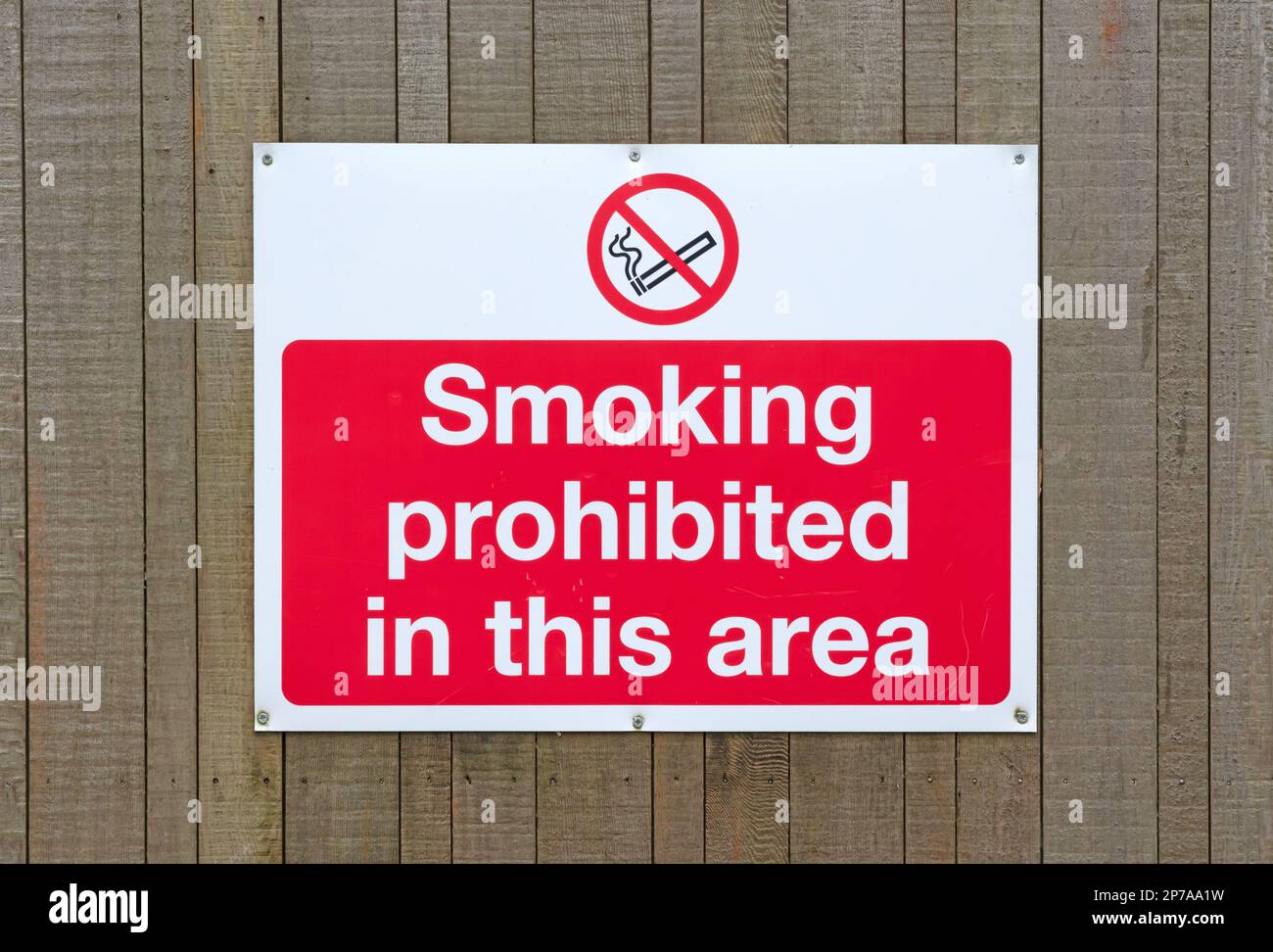 Plastic sign with text Smoking prohibited in this area, on wood wall ...