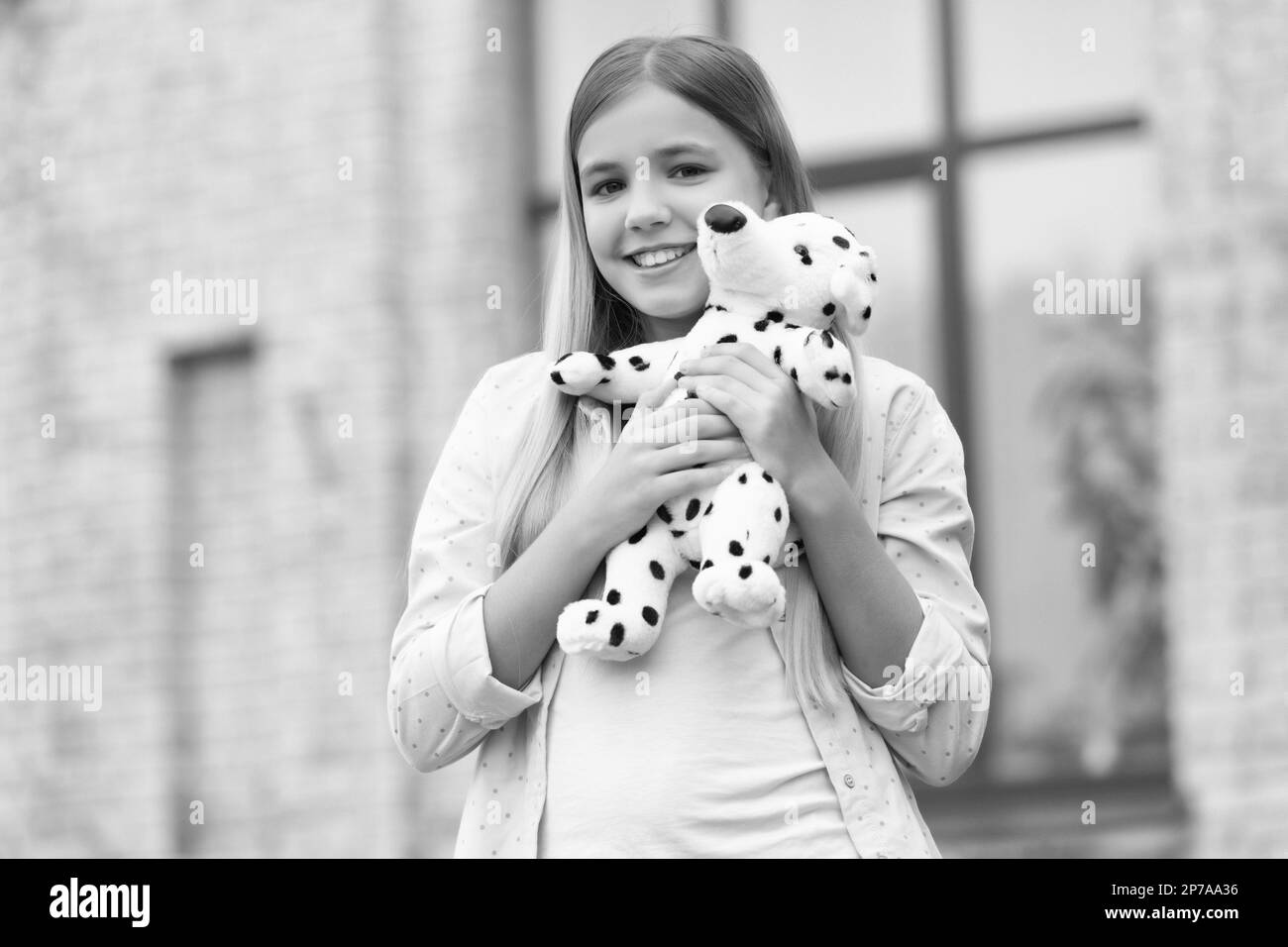 Happy girl child cuddling fluffy toy outdoors, childhood Stock Photo ...