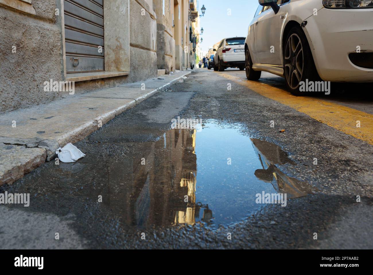 View of a natural street in Trapani with a puddle Stock Photo - Alamy