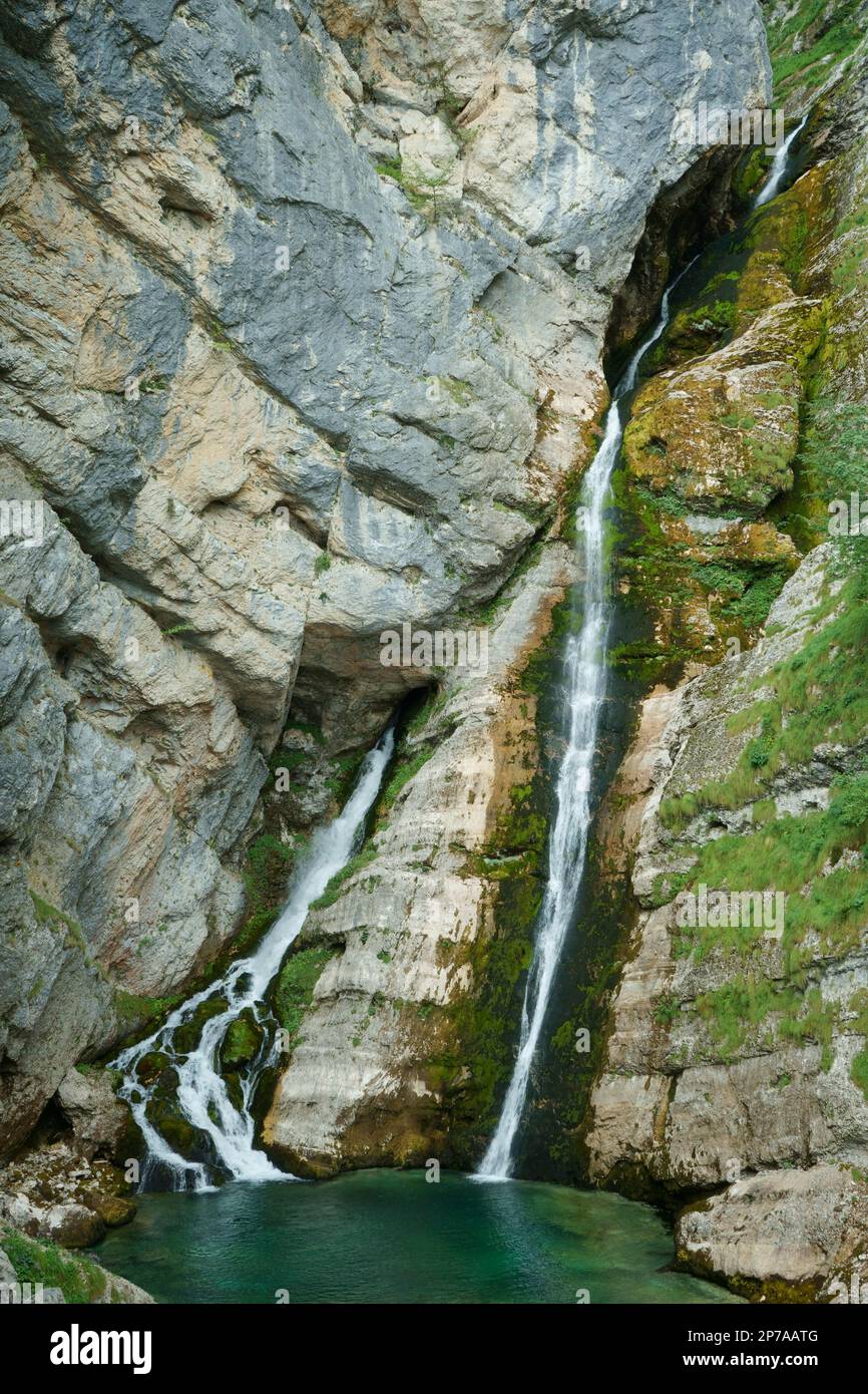 A waterfall (Slap Bohinjka) flows along a rock face. Slovenia, Ukanc ...