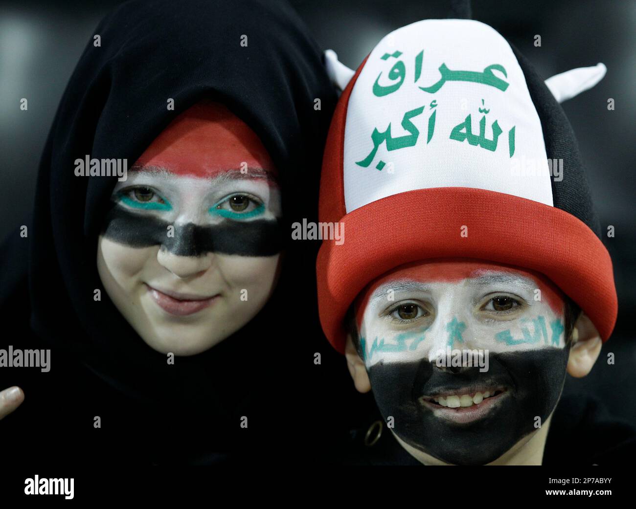 Iraqi soccer fans, looks on as they bearing faces paint in the colors ...