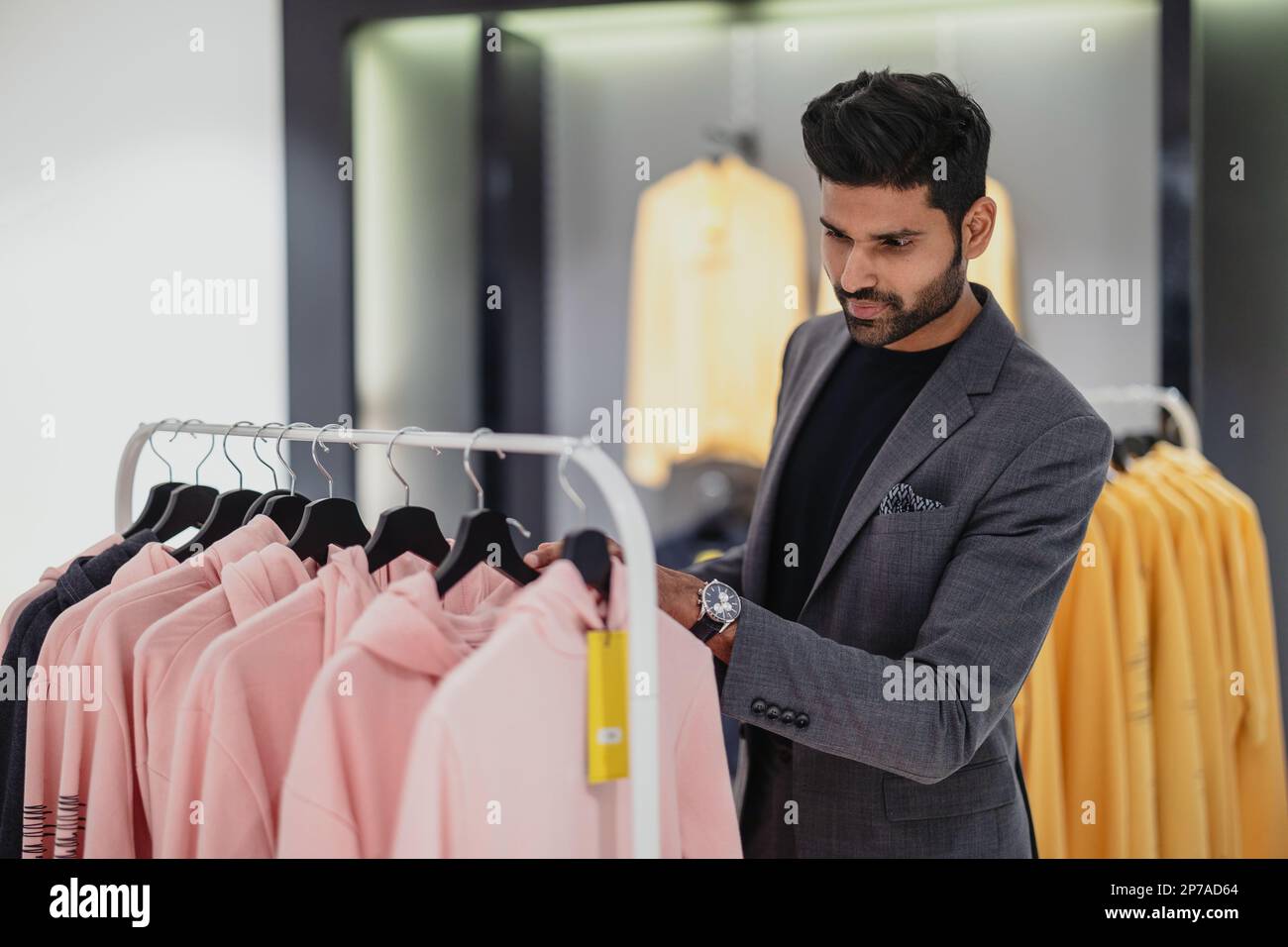 Young man shopping in clothing store Stock Photo - Alamy