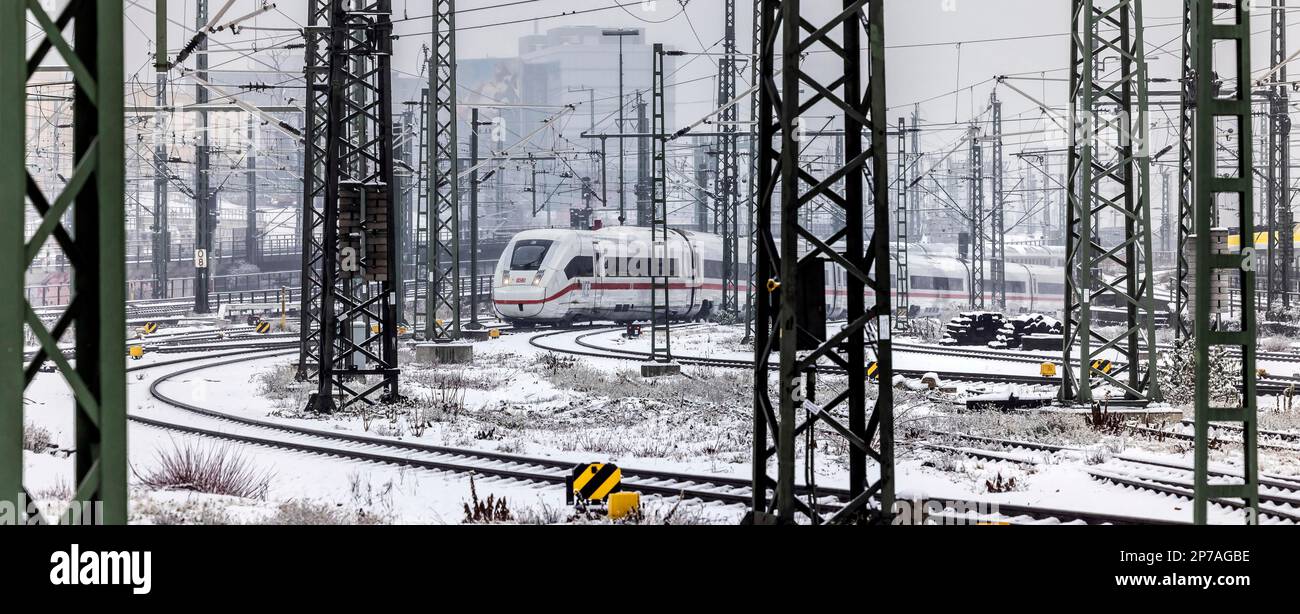 Snow lies on the tracks, a Deutsche Bahn ICE train entering the main ...