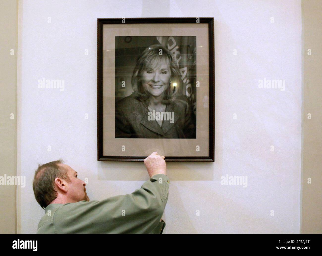 Tim Francis, of FrameMaster Gallery in Edmond, locks a portrait of ...