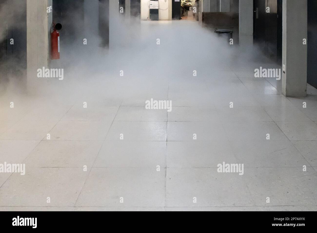 Dissipating cloud of nitrogen gas floating low inside building corridor ...