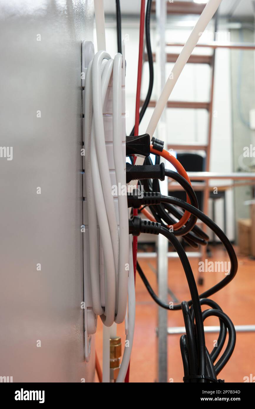 Messy power outlet cord extender fully plugged and suspended from above ...