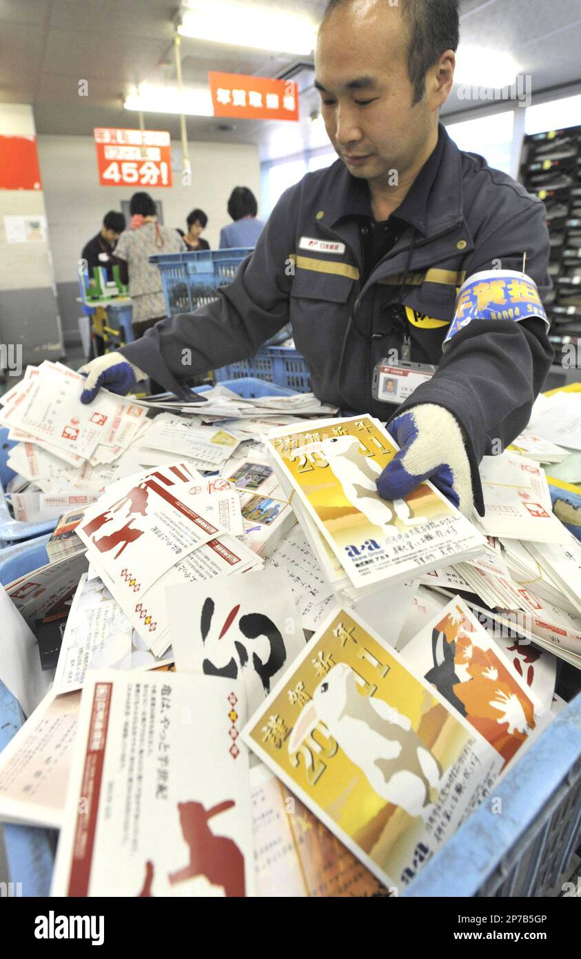 A worker of Japan Post Service Co.(JP) at Tokyo's Kanda Post Office ...