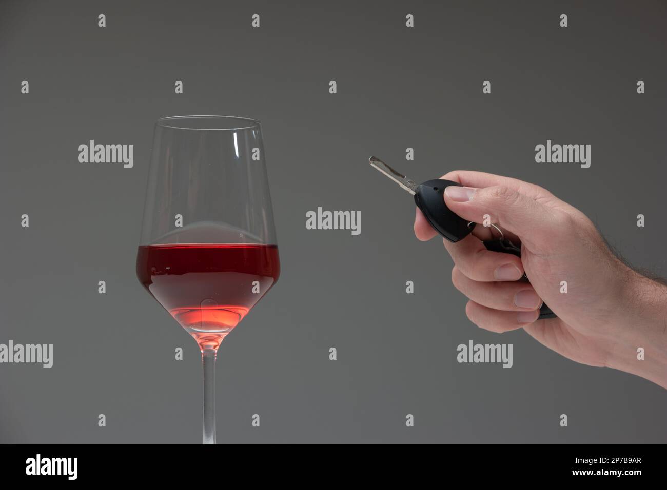 Drinking and driving concept shot. Male hand holding car keys next to ...