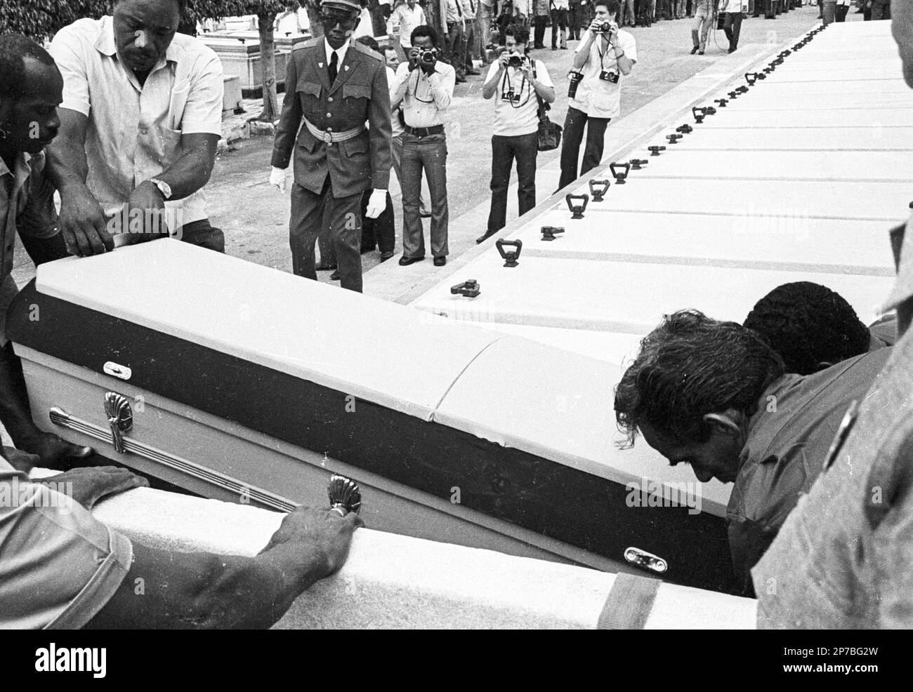Workers lower into a tomb, the coffin of a victim of a Cubana Airlines ...