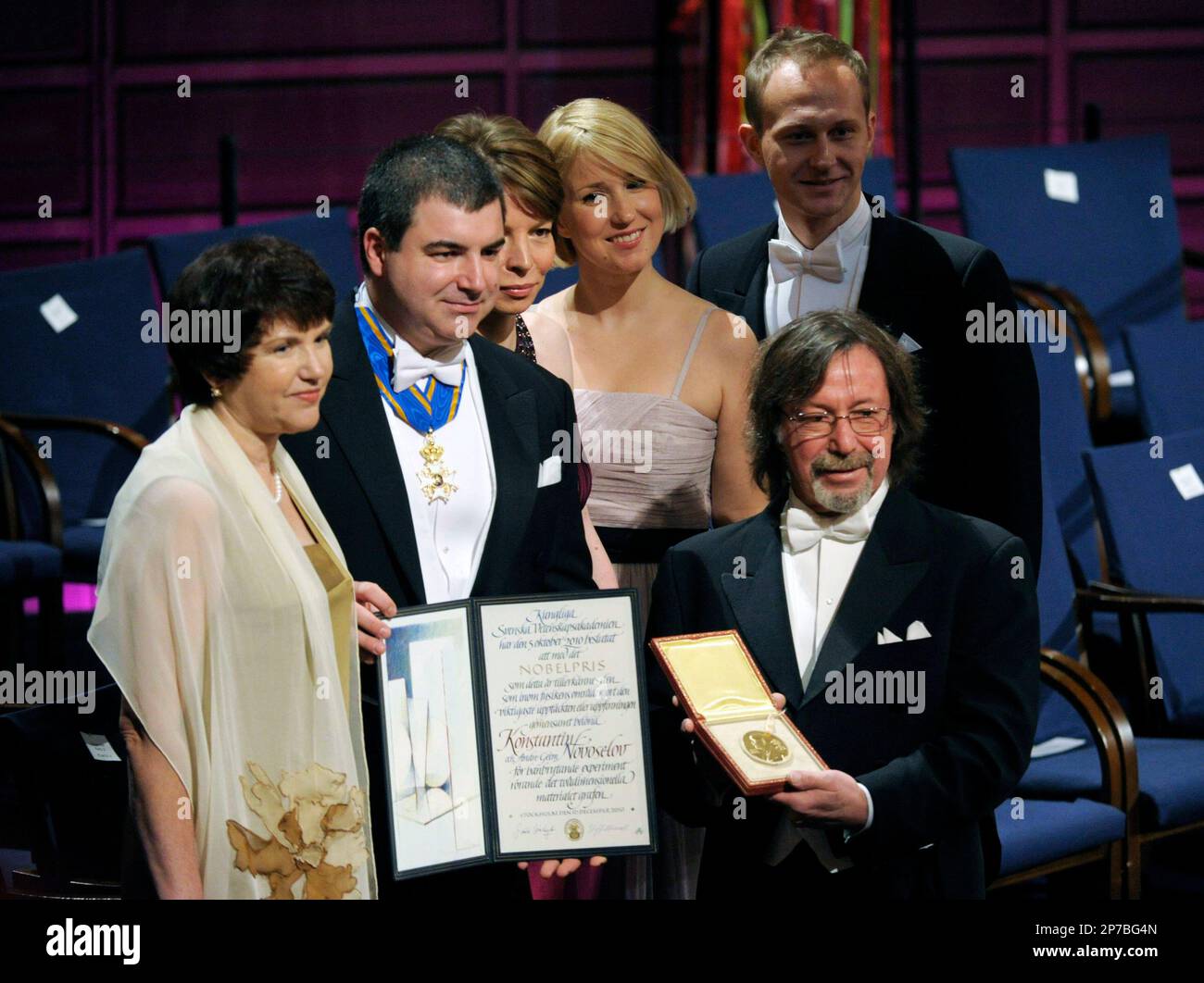 Konstantin Novoselov, second from left, displays his diploma and medal ...