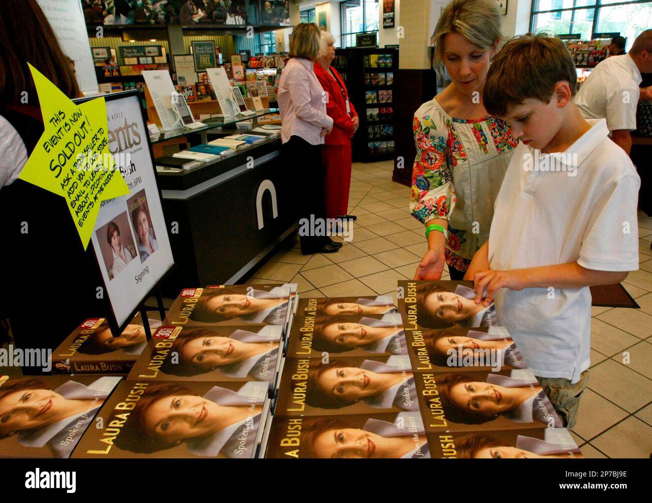 Joshua Marvel, 10, and his mother Kimberly Marvel look over a book ...