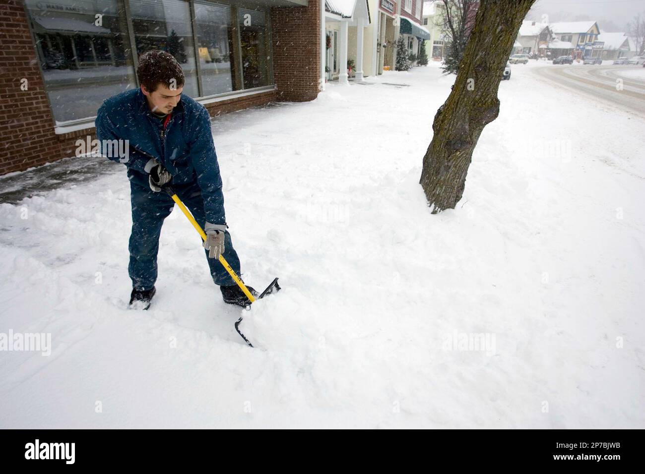 Jordan Newcomb, 18, shovels snow from the sidewalk in front of Edward's ...