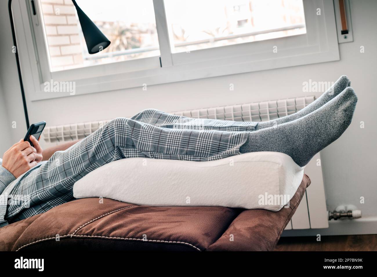closeup of a man resting on the sofa leaning his legs on a leg ...