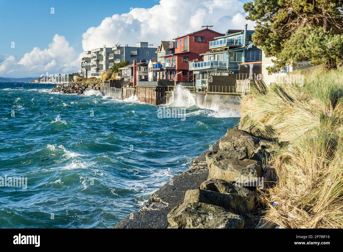 Waves on a windy day hit the shoreline near waterfront homes in West ...