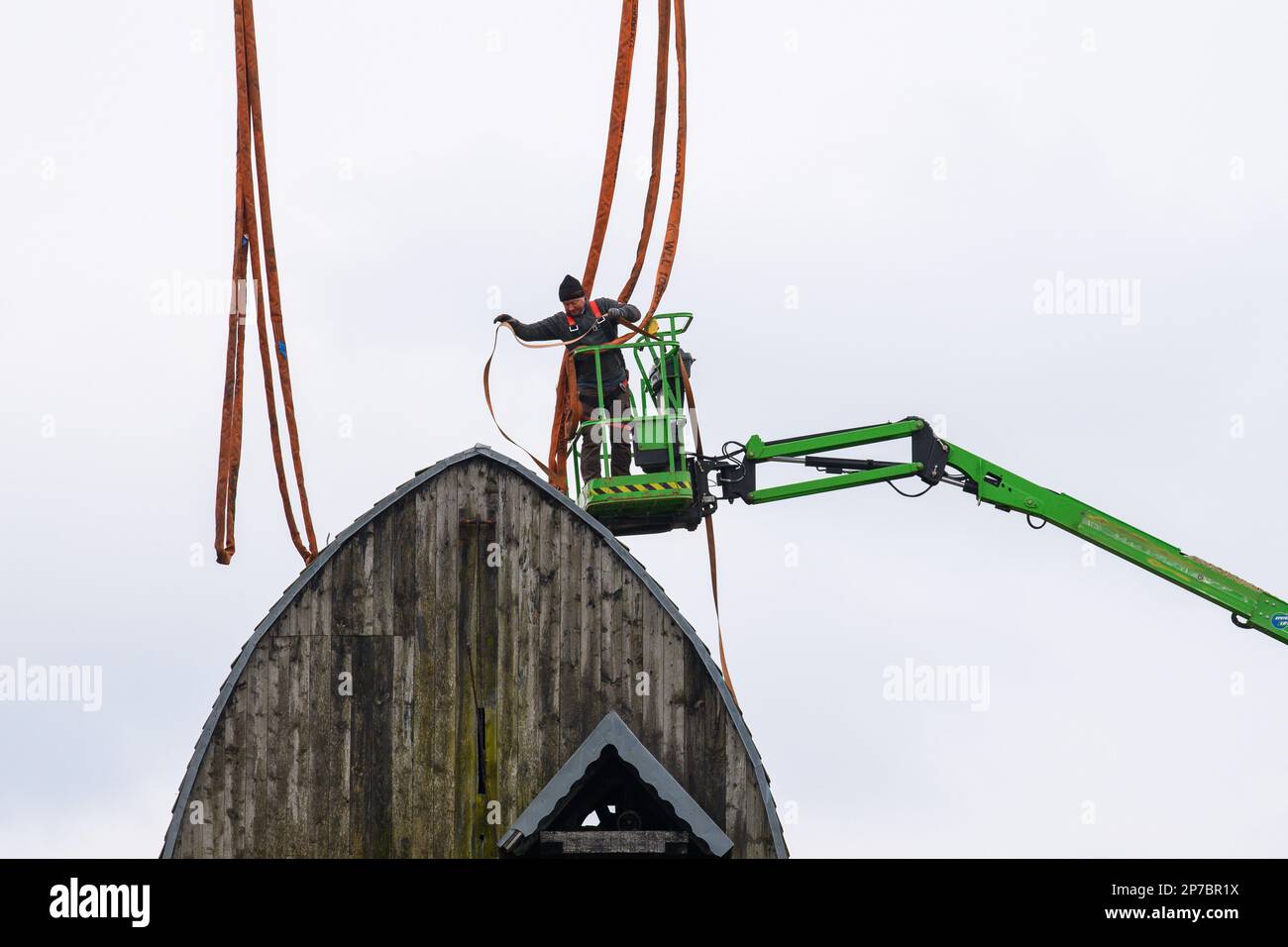 Etingen, Germany. 08th Mar, 2023. A worker throws a belt over the house ...