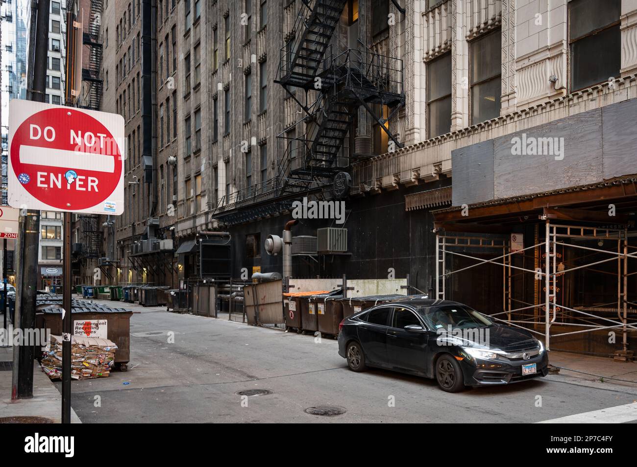 A stop sign on the side of a road near tall buildings Stock Photo - Alamy