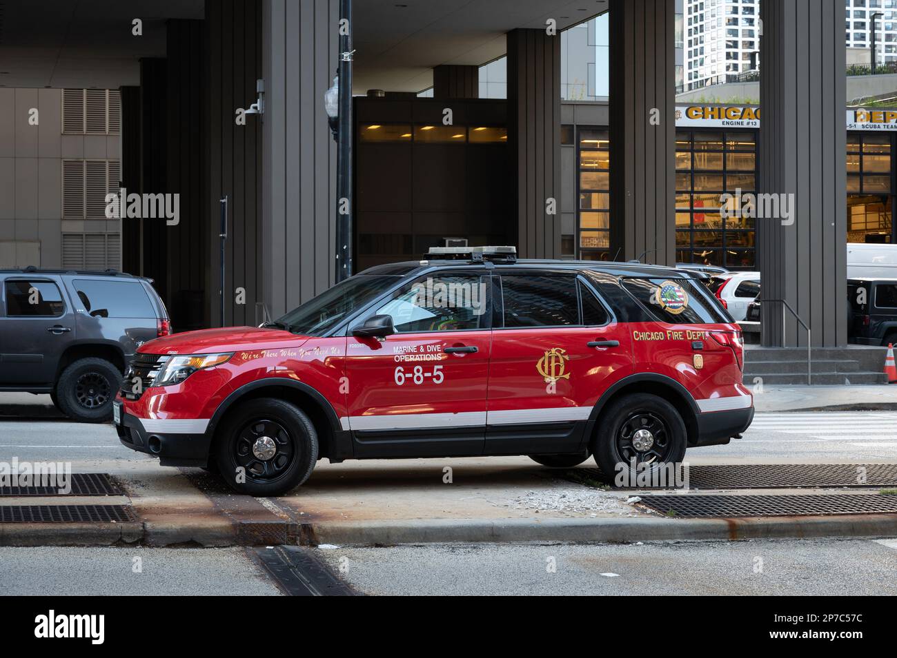 A Chicago fire department red car parked nearby a commercial buildings ...