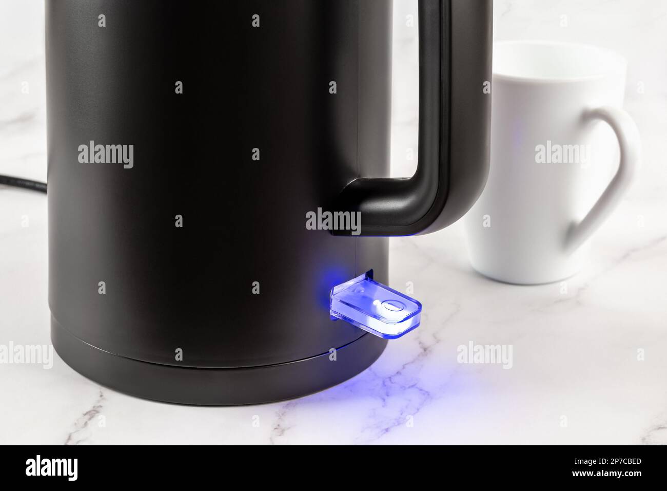 Electric kettle switch glows blue while turned on. Matte black kettle ...