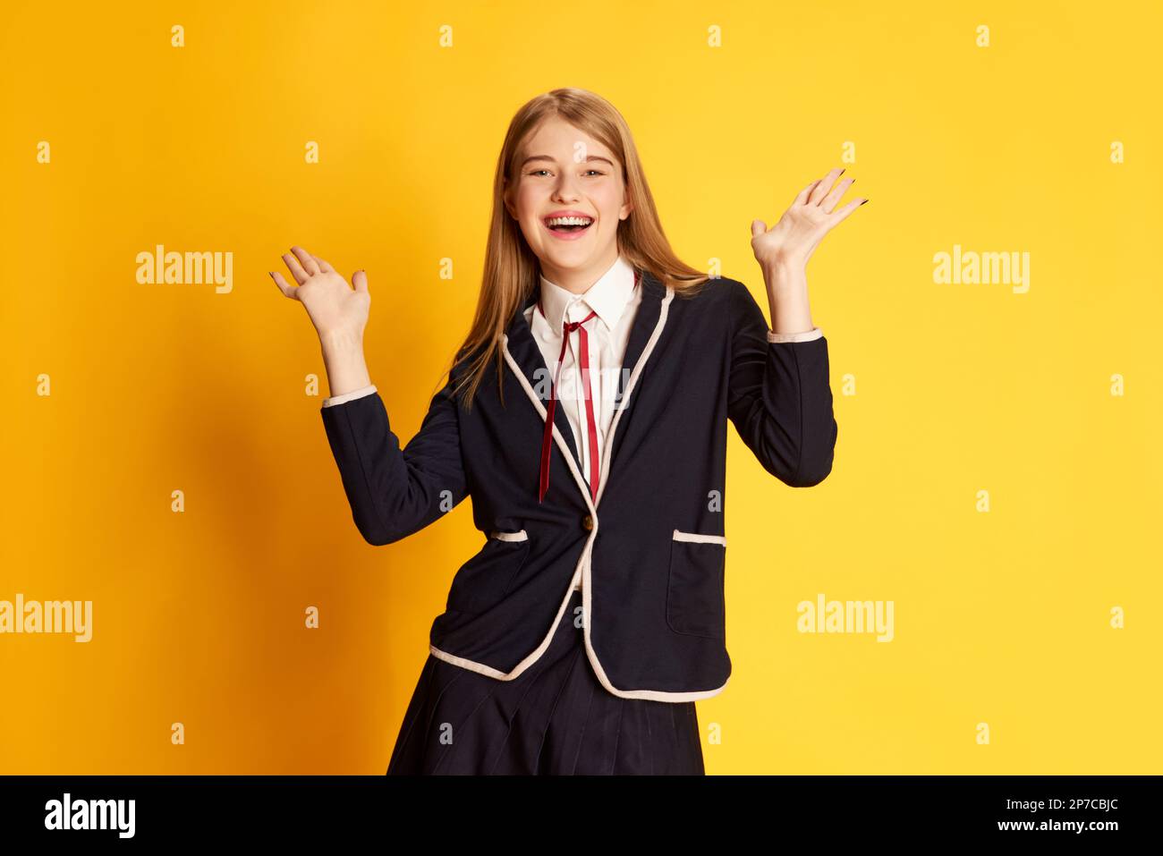 Success. Portrait of beautiful young girl, student in uniform posing ...
