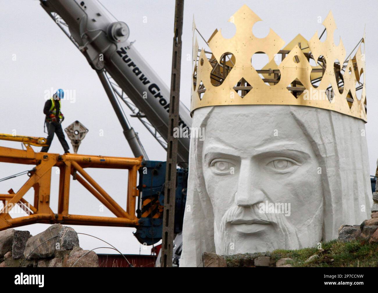 Workers struggling against wind to assemble a crane that is to lift 32 ...