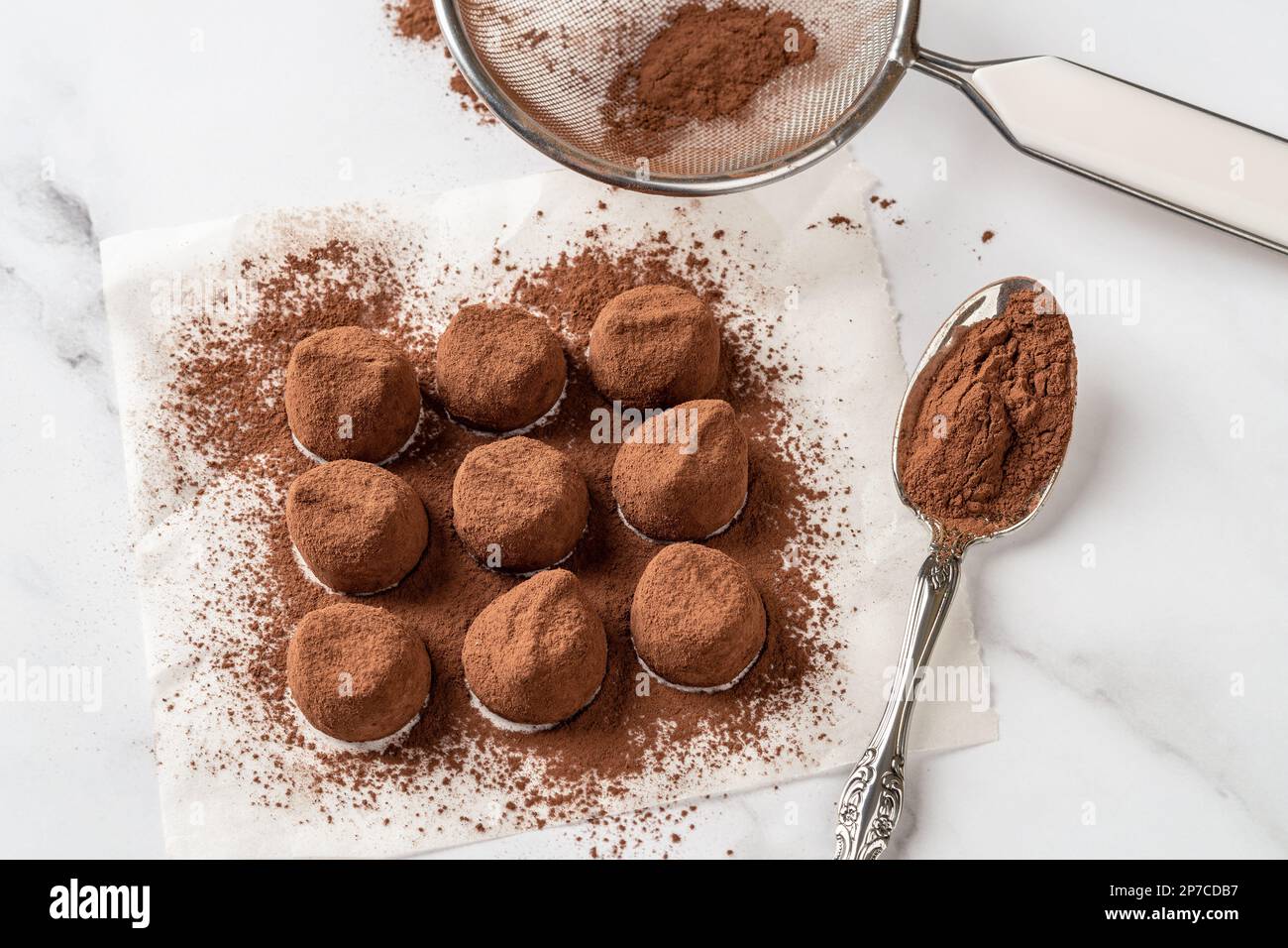 Delicious truffle balls sprinkled with cocoa powder. Homemade dark chocolate candy, mesh ...