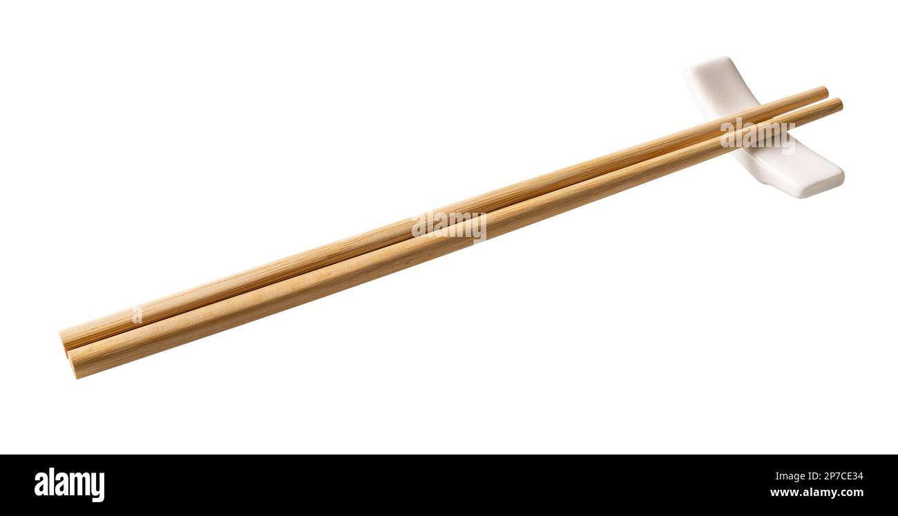 Wooden chopsticks on a white chopstick rest cutout. Pair of bamboo ...