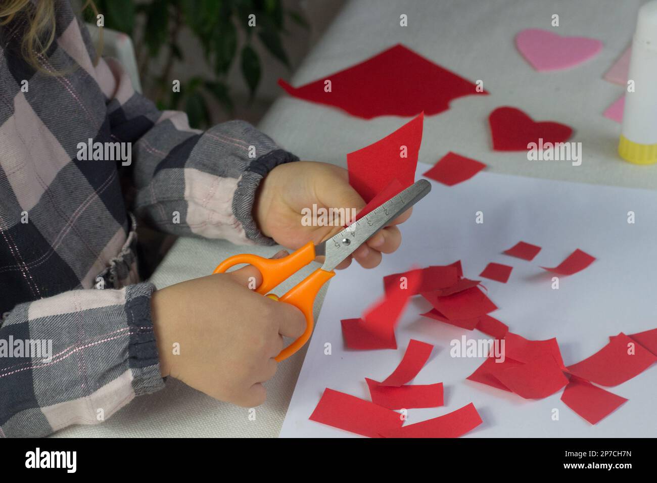 Little girl making red heart applique with paper and glue Stock Photo ...