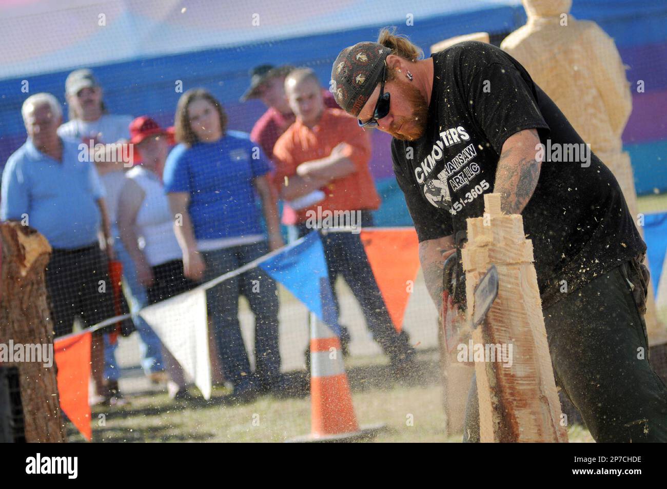 Chainsaw artist Brian Ackley carves a lighthouse out of a log as a ...