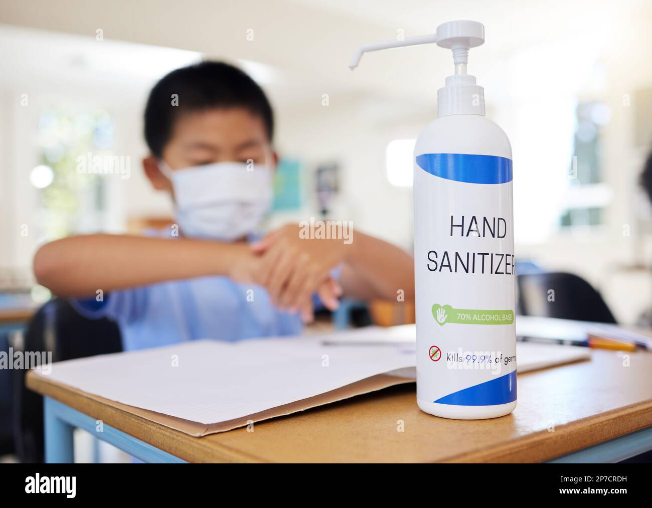 Boy rubbing hand sanitizer for hygiene, safety and protection against ...