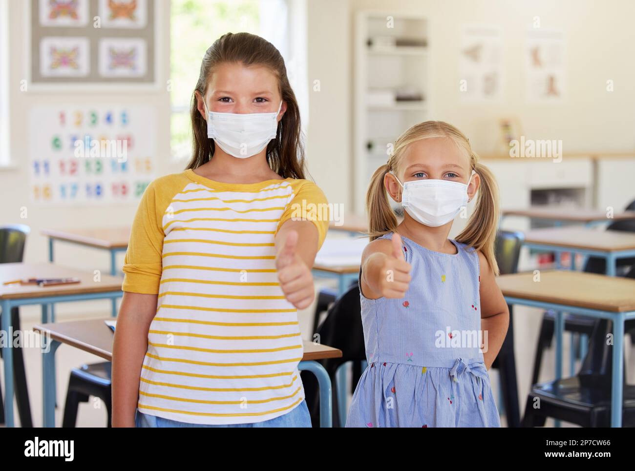School kids, thumbs up and healthy students wearing masks in a ...