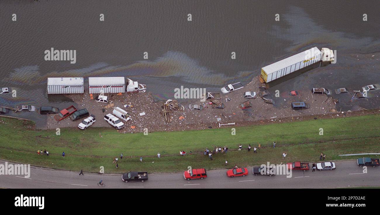 Trucks, cars and debris are washed up against the retaining wall of I ...