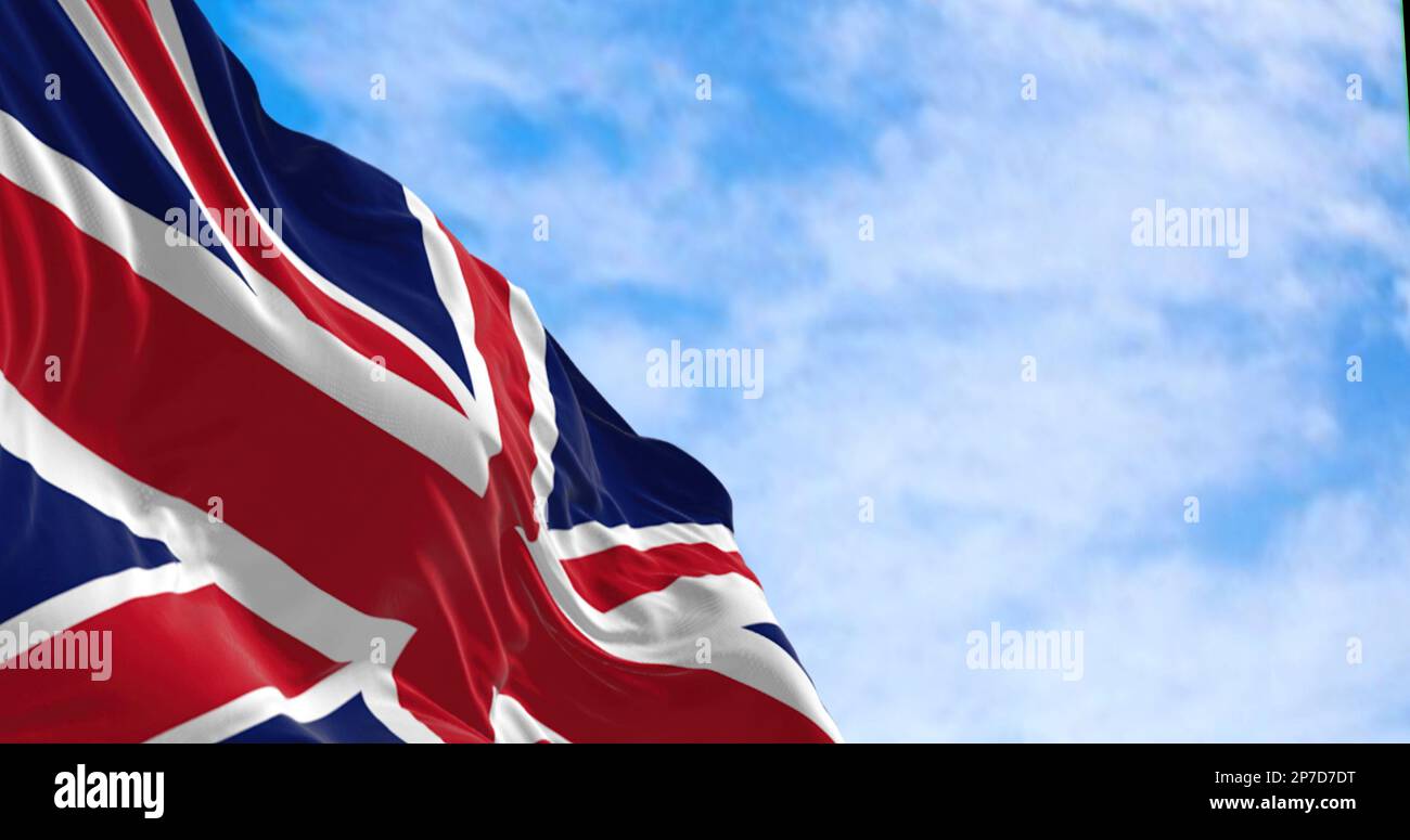 United Kingdom flag waving in the wind on a clear day. Union Jack. Blue ...