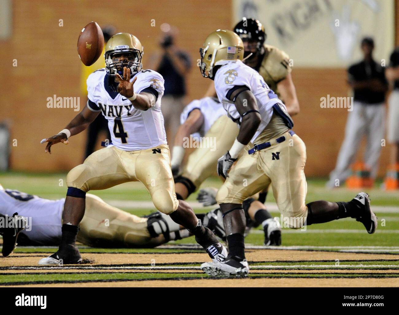 Navy quarterback Ricky Dobbs hands the ball off to Gee Gee Greene ...