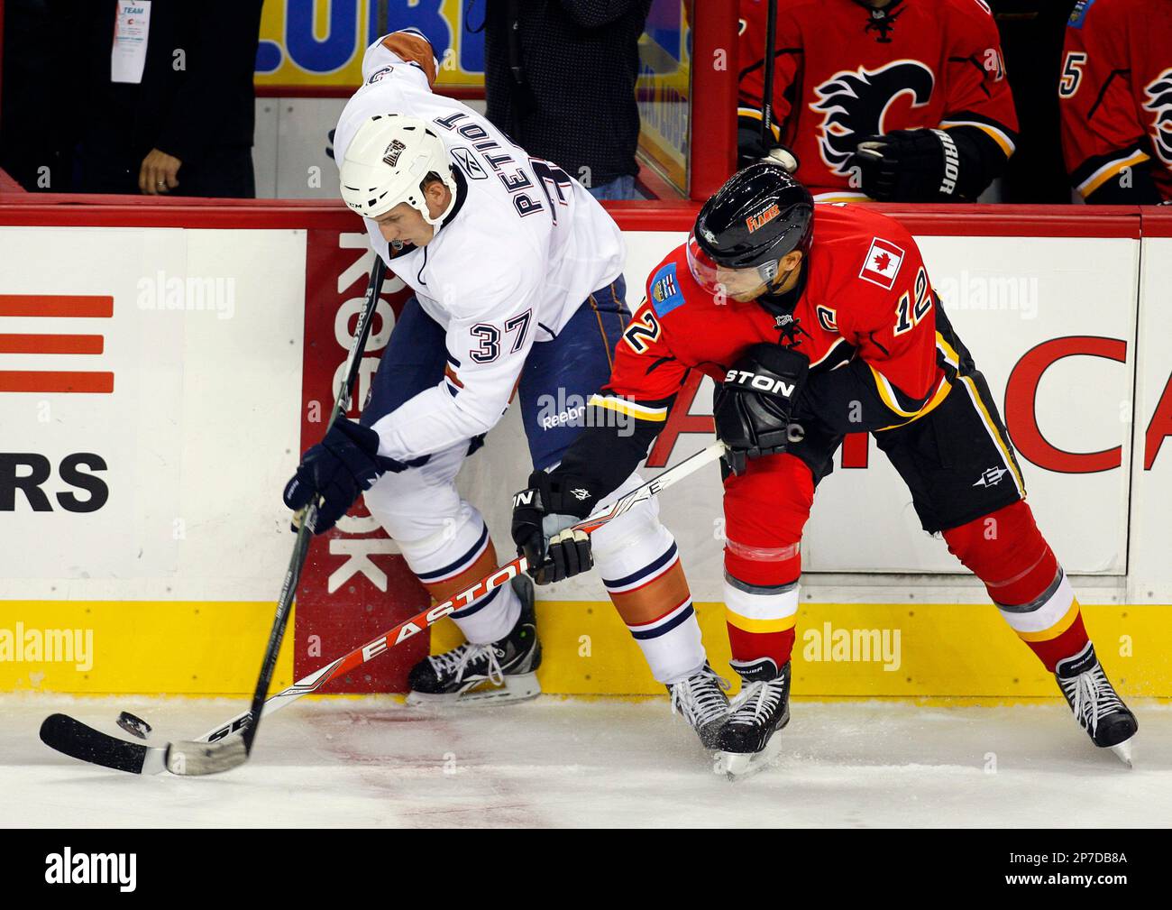 Edmonton Oilers' Richard Petiot, left, fights for the puck with Calgary ...