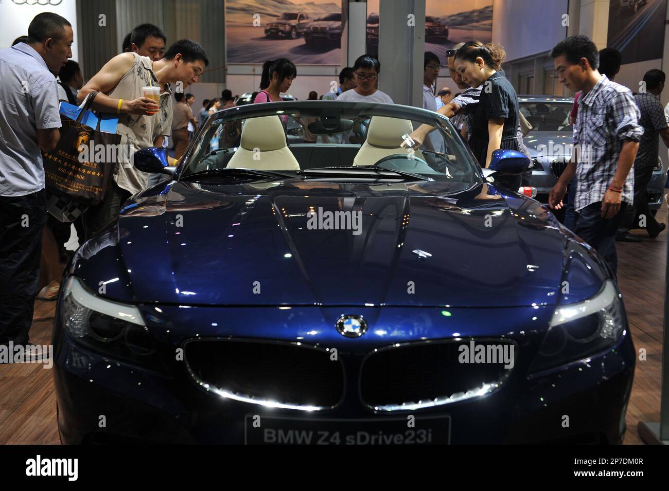 Visitors look at a BMW car during the 13th Chengdu International Auto ...