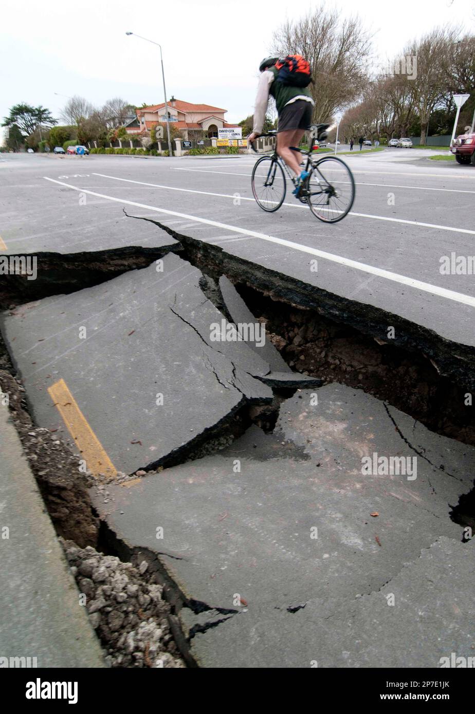 A person cycles past a damaged road near the Avon River following ...