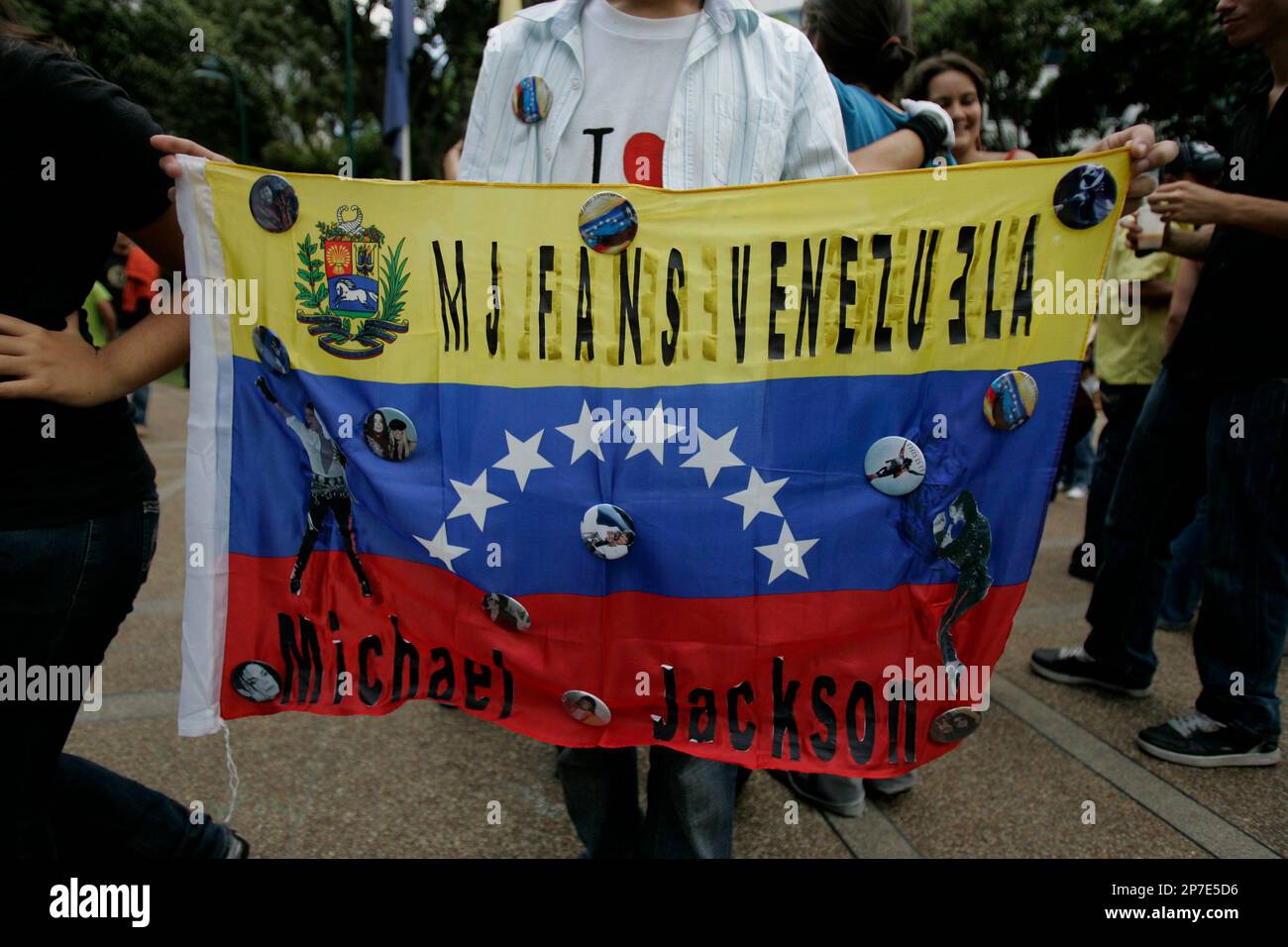 A Michael Jackson's fan carries a Venezuelan flag during an event ...