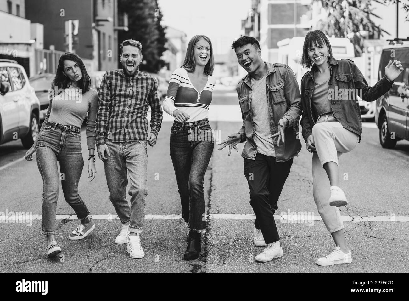 Multicultural friends walking at city center acting funny crazy moves ...