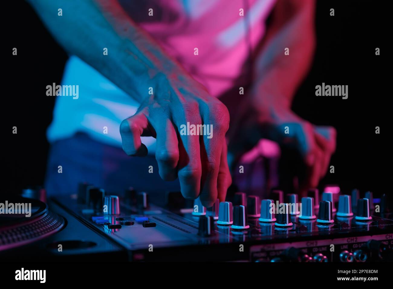 DJ mixing music on party. Club disc jockey adjusting volume on sound ...