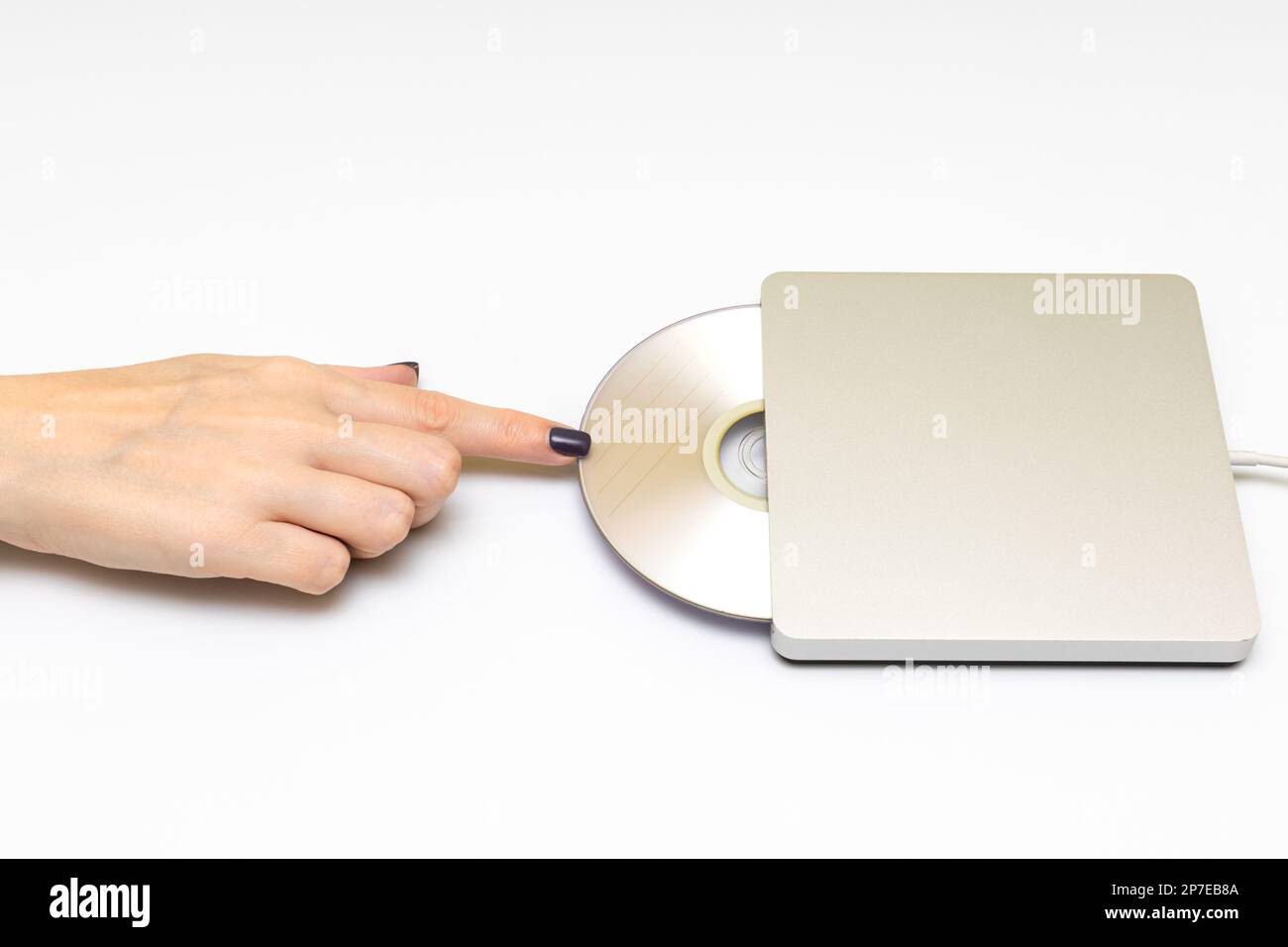 woman inserting a laser disc into a disk drive. hand inserts disk into ...