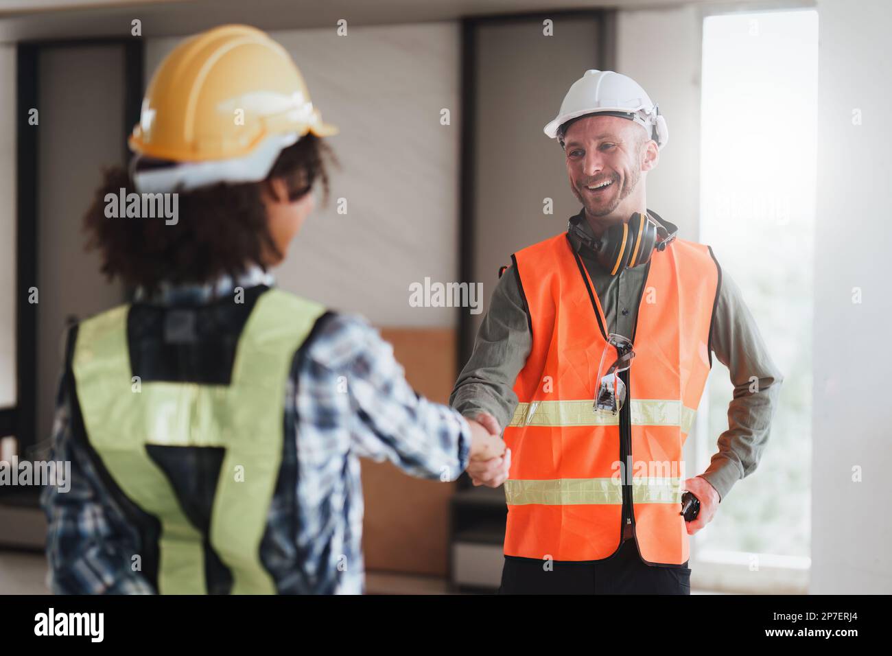 Architect or engineer and foreman construction workers shaking hands ...