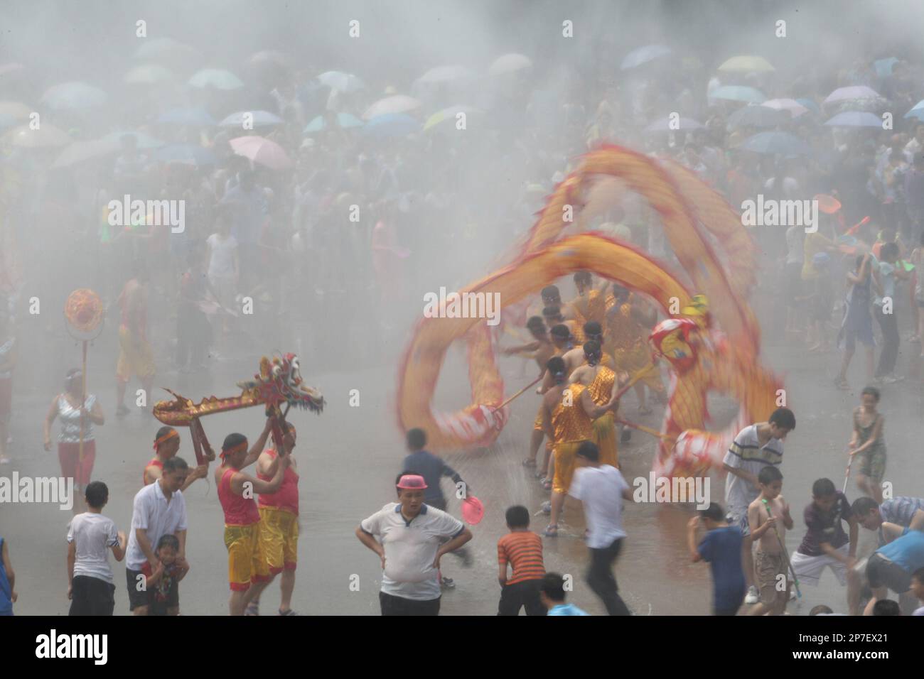 People splash water as artists perform dragon dance to celebrate the ...