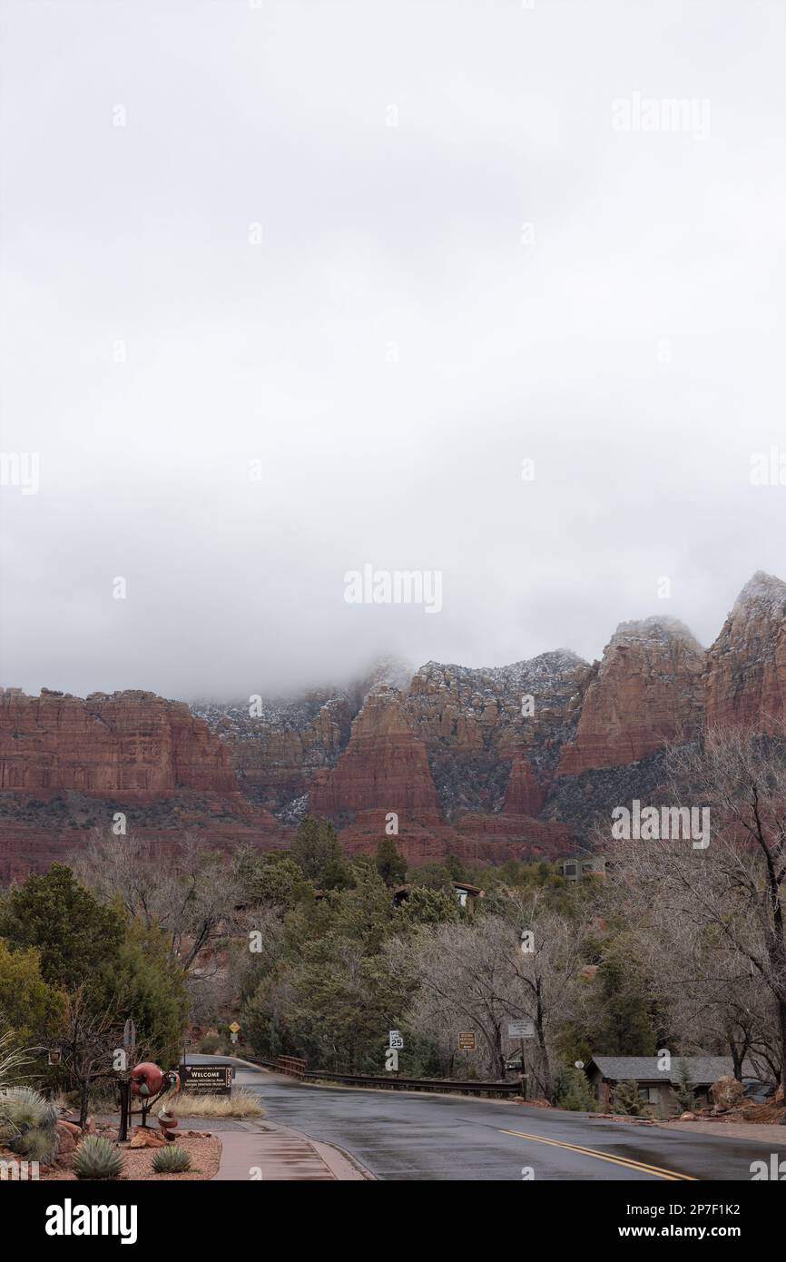 A street in Sedona, Arizona, with misty red rock mountains in the ...