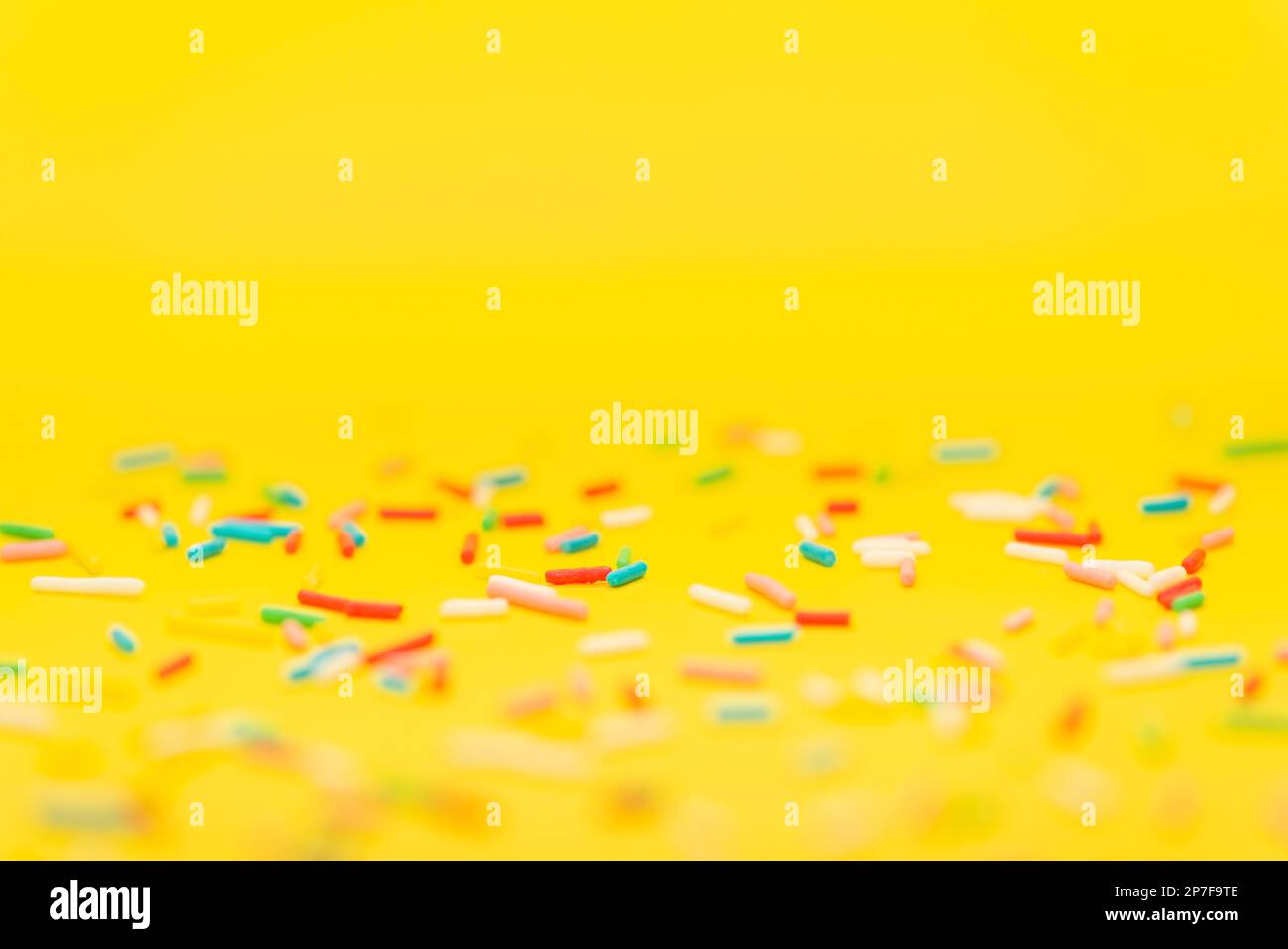 colorful sprinkles over yellow background, copy space Stock Photo - Alamy