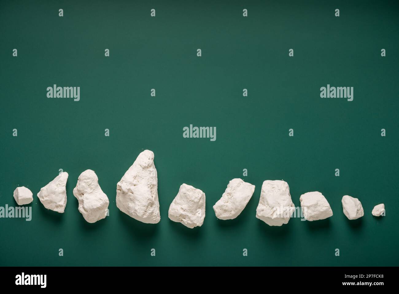 natural pieces of chalk mineral stones is on green chalkboard ...