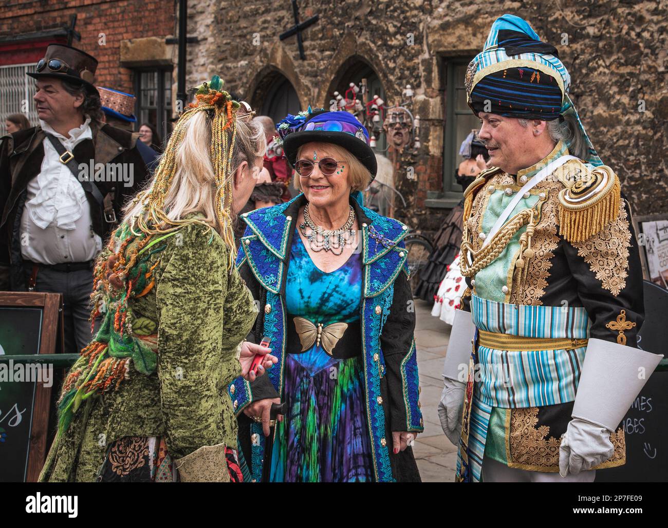 A group of friends enjoying a conversation at a steampunk event Stock ...